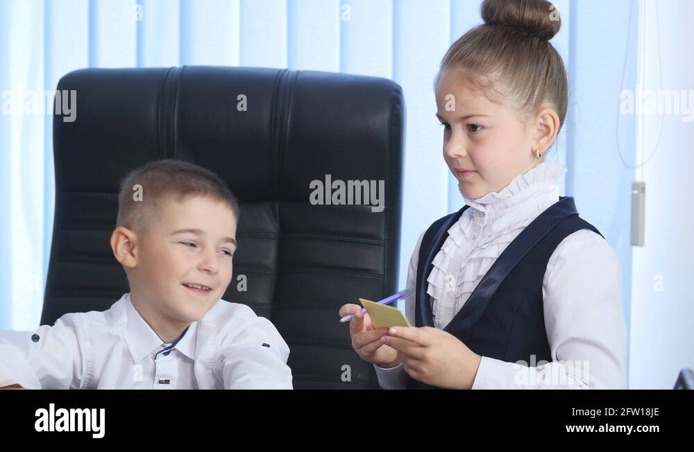 Little boss and secretary. Cheerful little boy in suit gives orders ...