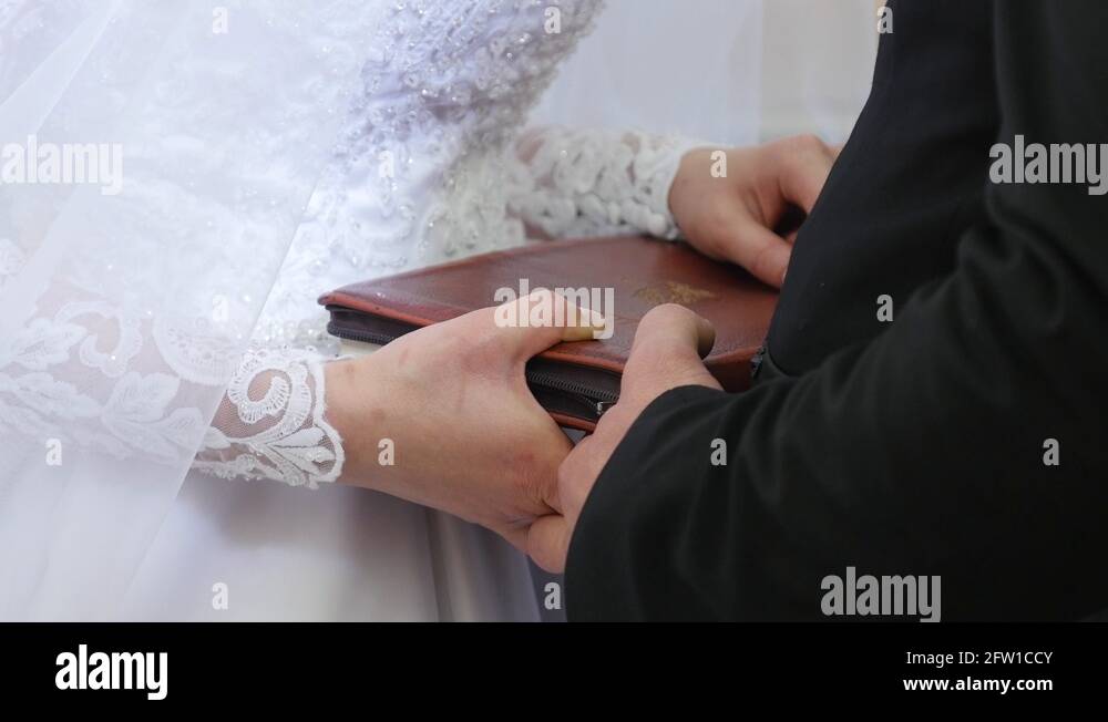 Bride And Groom Hands On Bible. Bride and Groom place their hands on ...