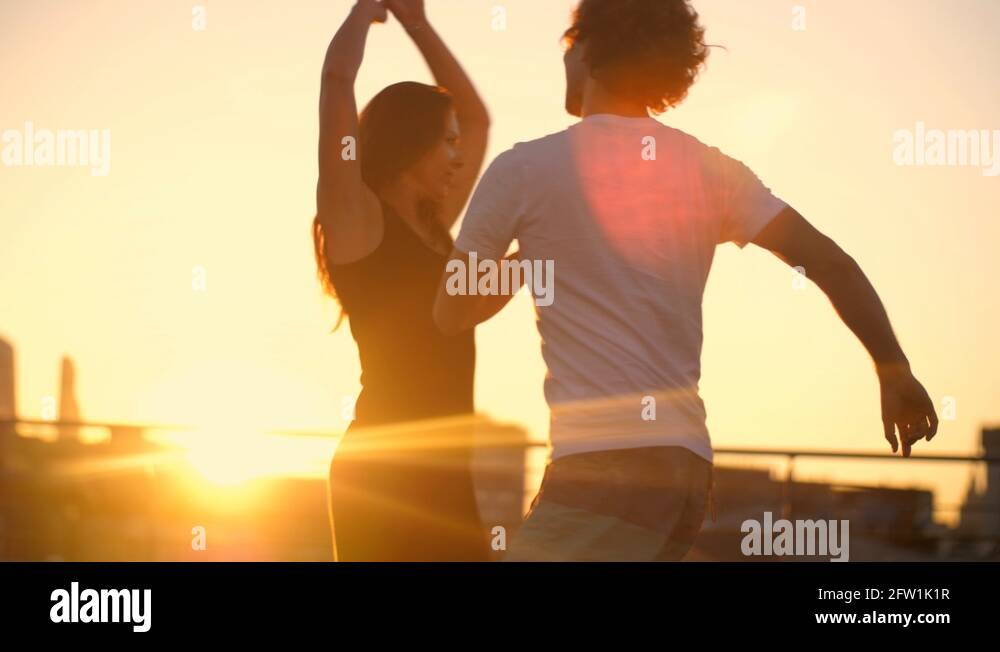 Young couple dancing zouk dance rooftop city skyline sunset sun 4K slow ...