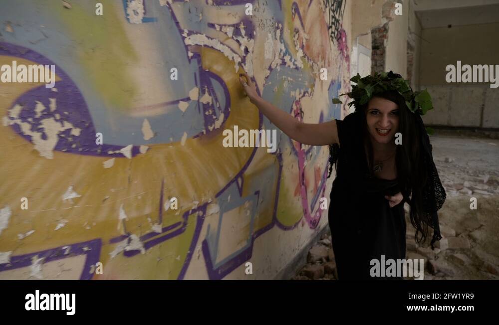 Mad young girl dressed as a witch with evil sneer scratching wall of ...