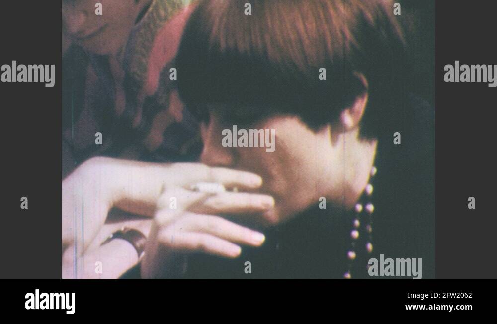 1970s: Men smoke cigarettes, blow smoke. Woman lights cigarette, smokes ...