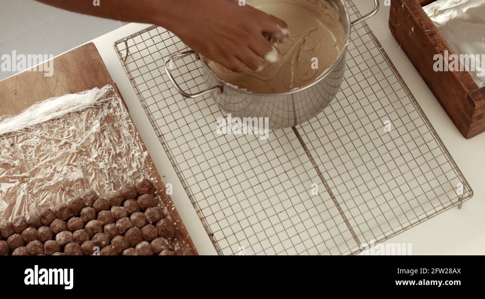 Chocolate master in his factory makes a truffles. Chocolate truffles ...