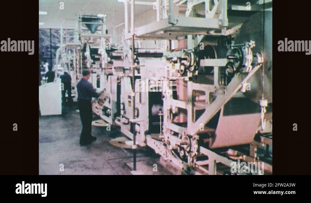1970s: Man opens a newspaper standing in front of printing press ...