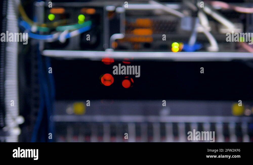 Network activity lights blink in red and green inside a data center ...