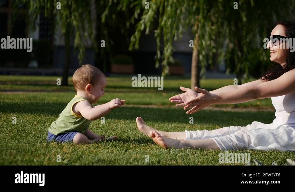 The kid is pulling his mother's hands. The baby takes the first steps ...