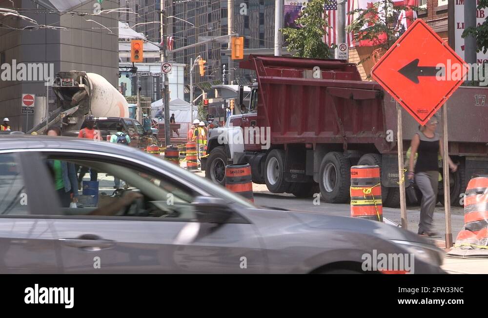 Road construction and pedestrian traffic on dusty hot summer day in the ...