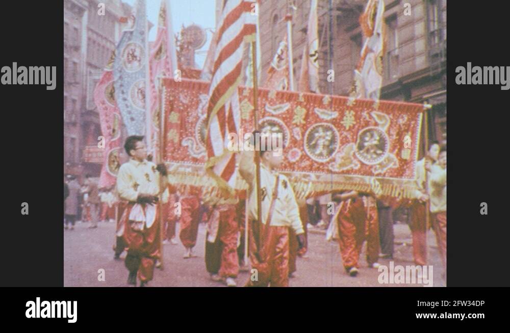 1960s: Chinese people in traditional clothing hold banner, walk in ...