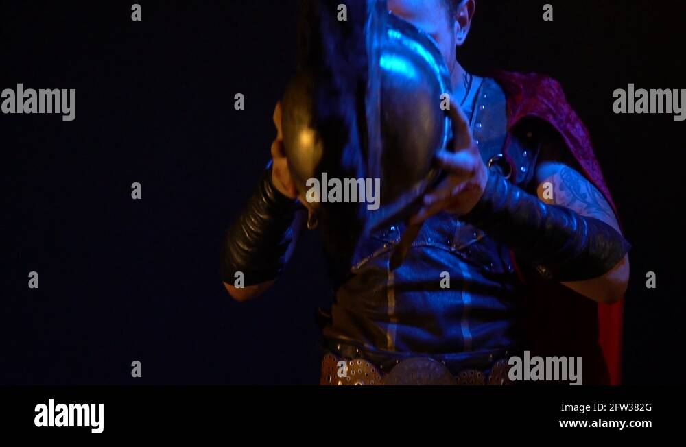 The dark haired Roman gladiator in leather armor and cloak wears a ...