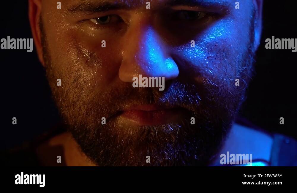 Sweaty bearded man with a beard and a scar on his cheek is seriously ...