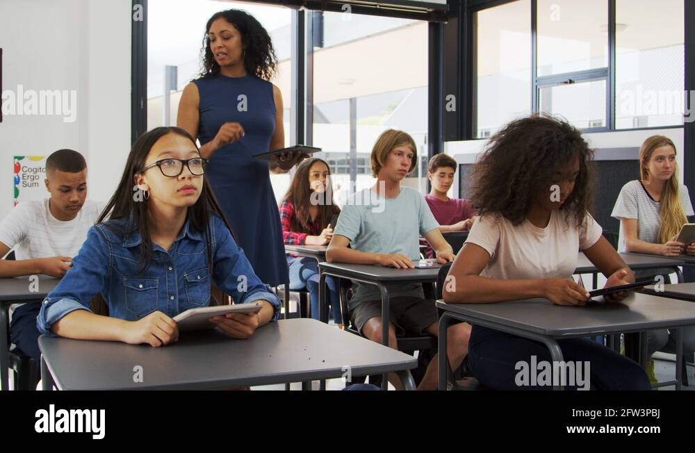Teacher addressing pupils from the back of her high school class Stock ...
