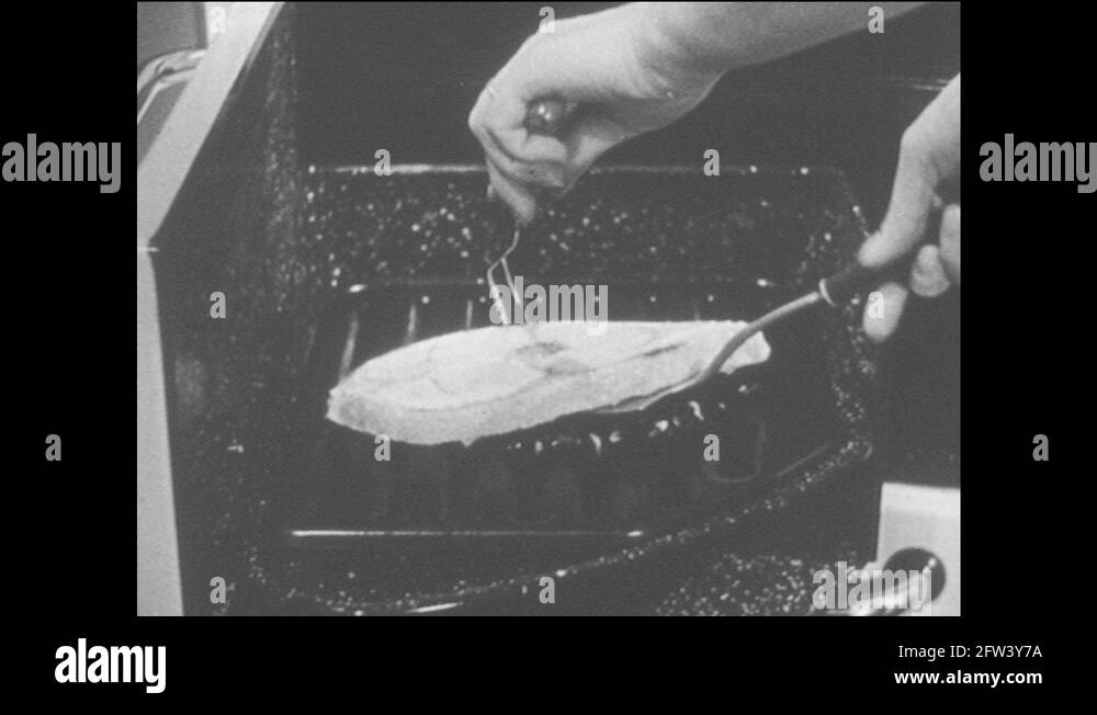 1940s: Hands flip fish on grill. Hands stuffing fish. Woman in kitchen ...