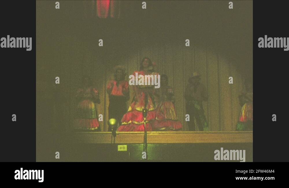 1940s: Dancers in costume dance on stage. Woman stands at microphone ...