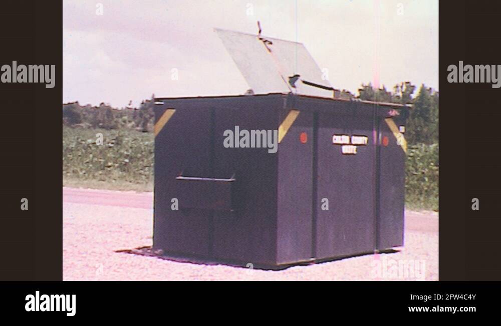 1970s: UNITED STATES: waste container system. View through window of ...