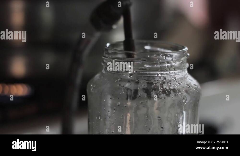 Alcohol distillation equipment, hooch fluid flow into glass jar Stock ...