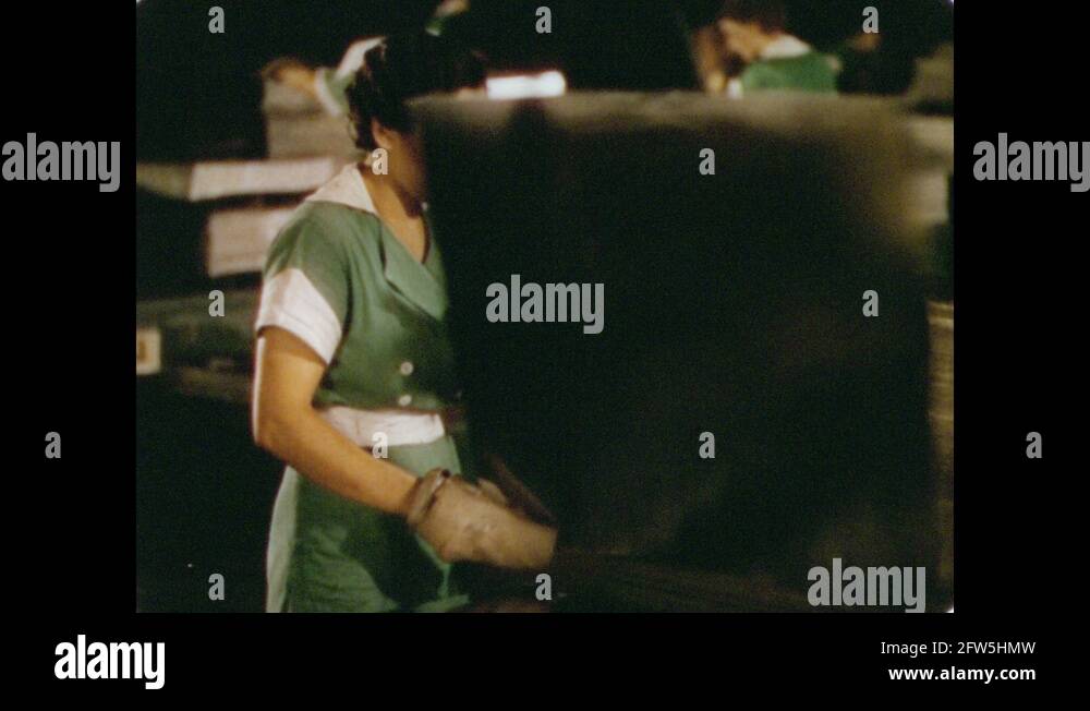 1950s: UNITED STATES: lady works in steel sheet factory. Tin plate mill ...