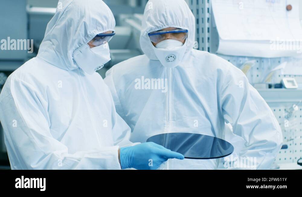 Two Scientists in Sterile Suits Check Semiconductor Silicon Wafer Stock ...