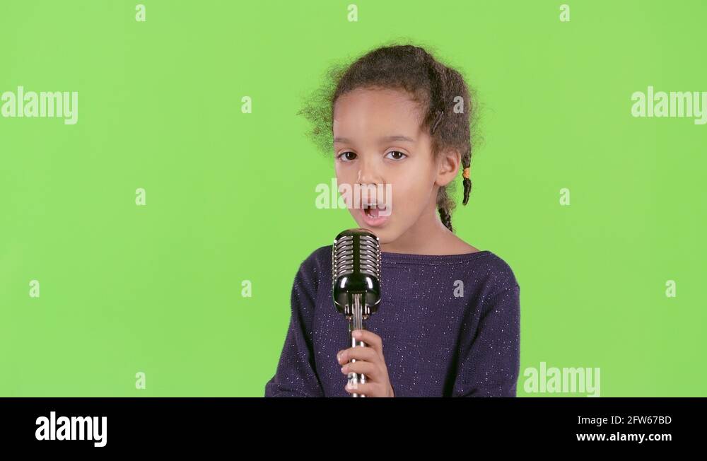 Baby of an african american girl singing in a retro microphone. Green ...