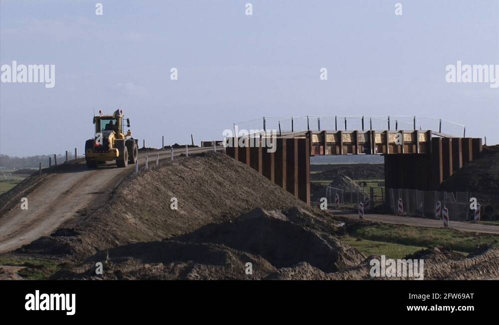 tractor, construction vehicle across a temporary bridge with retaining ...