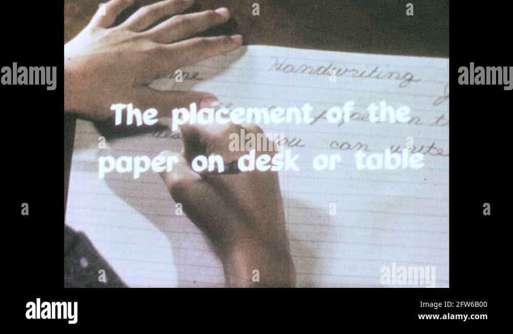1960s: hands write cursive words on lined paper on desktop in school ...