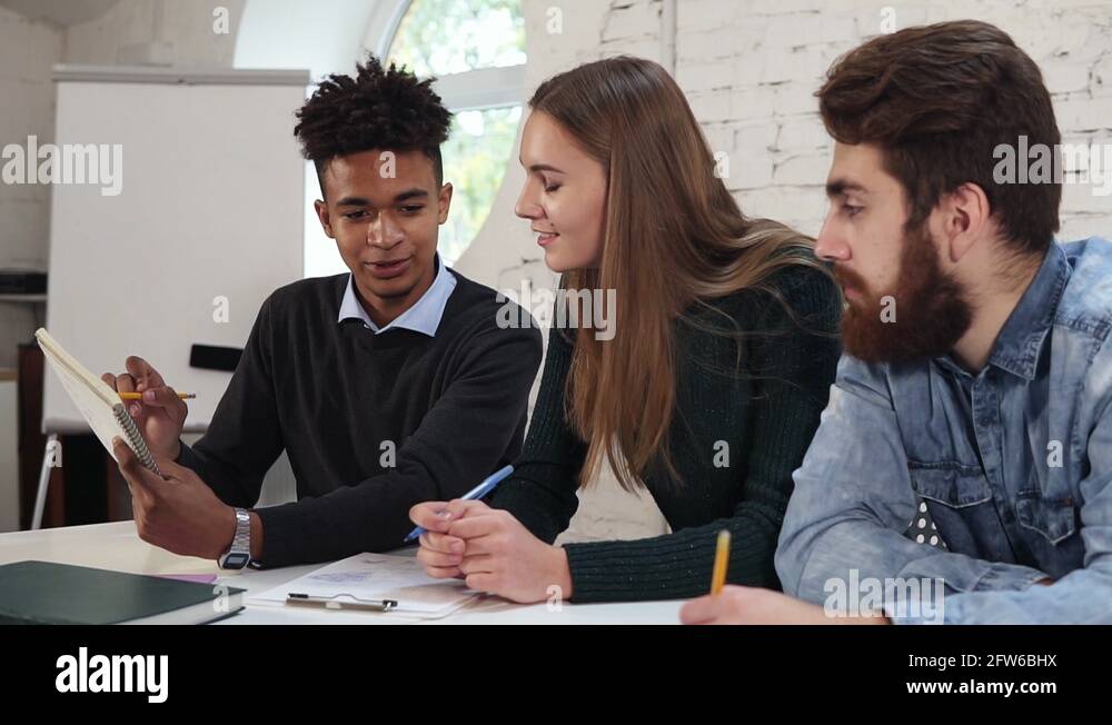 Young african guy explaining something to his collegues. Happy diverse ...