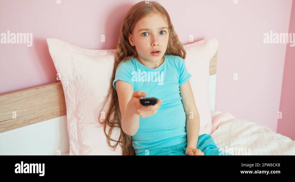 Laughing child girl 9 years old using TV remote control Stock Video ...