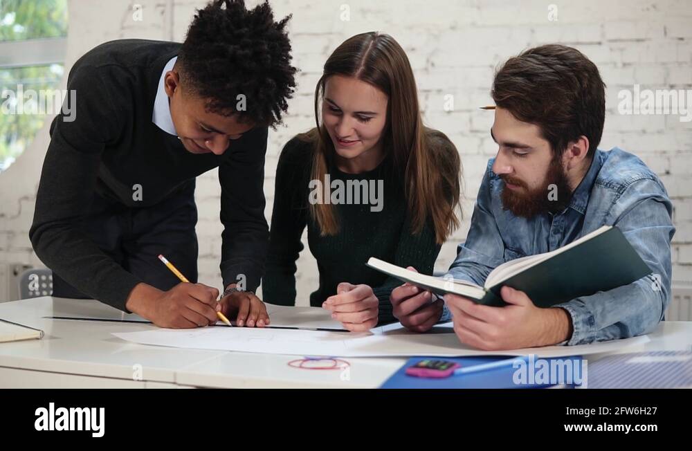 Diverse group of people working together drawing a plan, working on ...