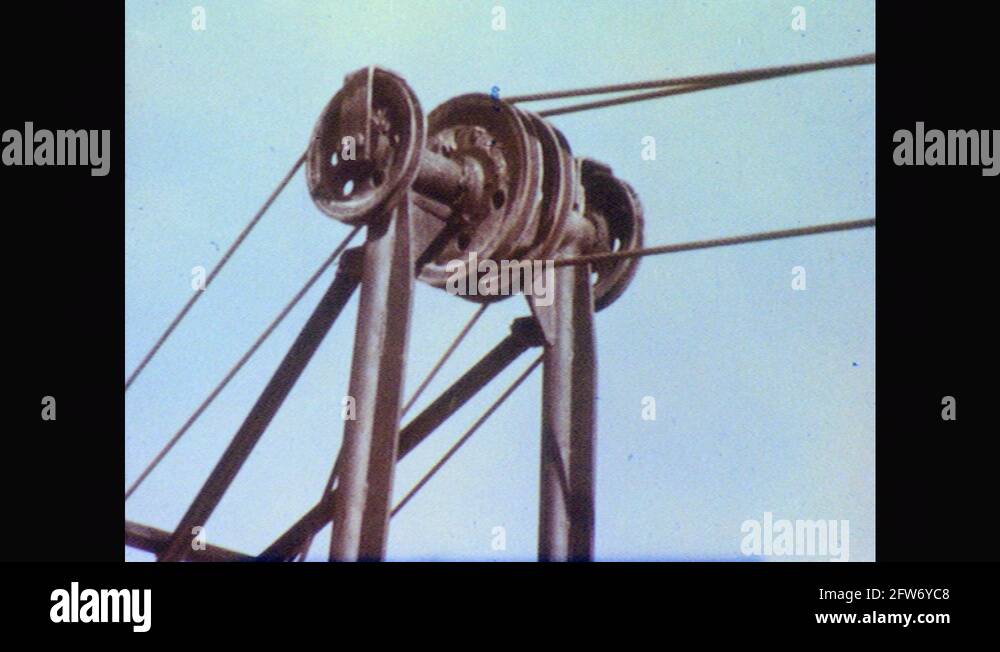 1960s: Pulley moves with cables from excavator. Man operates excavator ...
