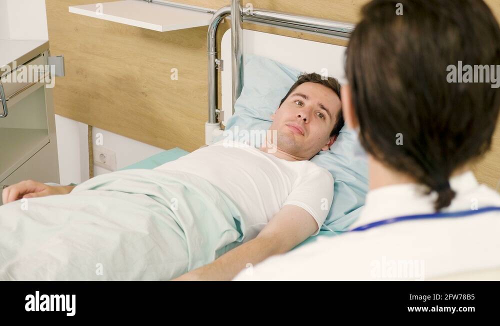 Young Doctor taking care of a patient who is sleeping in the bed Stock ...