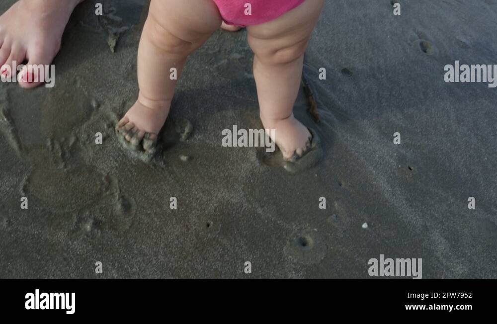Baby Toes Kicking and Playing in Wet Sand Stock Video Footage - Alamy