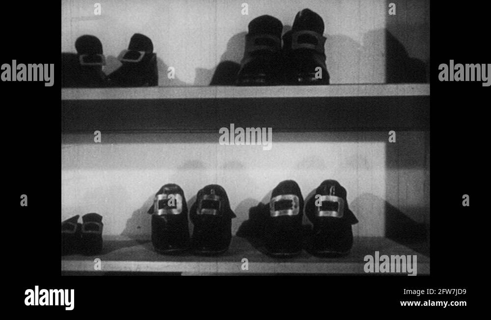 1940s: Colonial style shoes sit on shelves. Man picks up shoe from ...