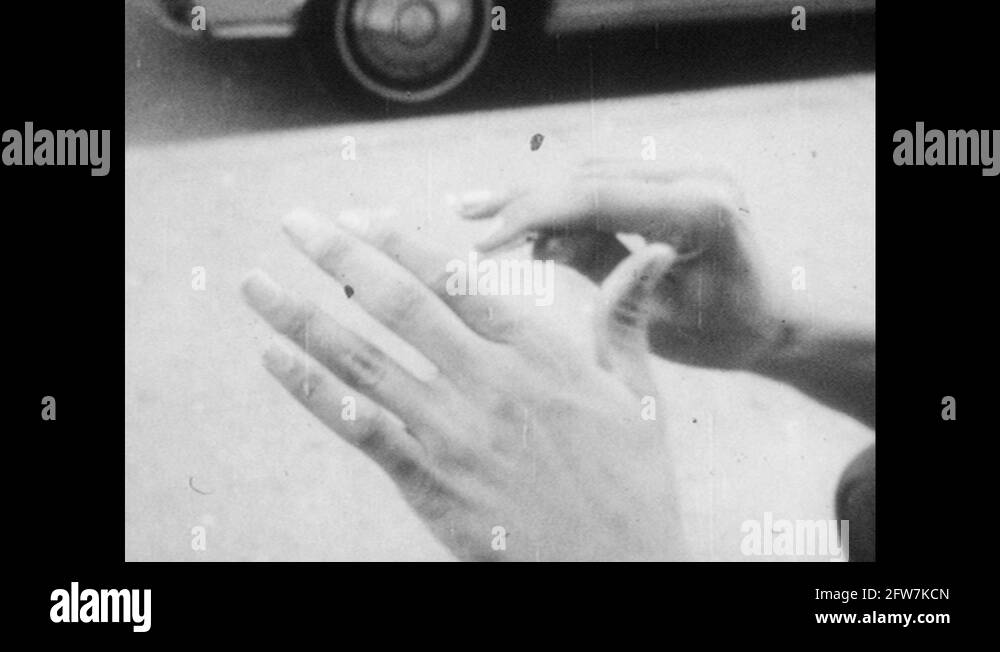 1960s: Close up, hands fold knife. Boy smoking on steps, puts on hat ...