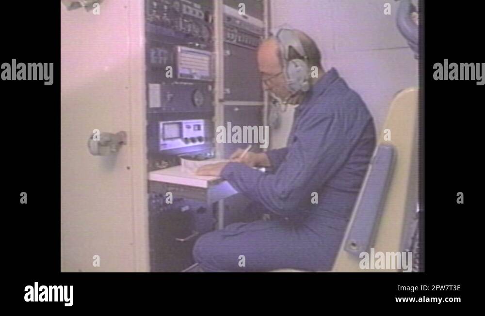 1970s: Man at control panel. People on control room. Man looking at ...