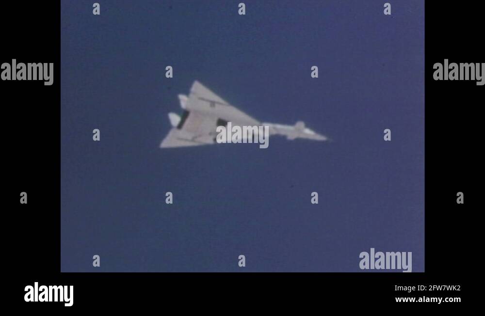 1960s: Supersonic plane flies through sky. Text on screen. Fighter jet ...