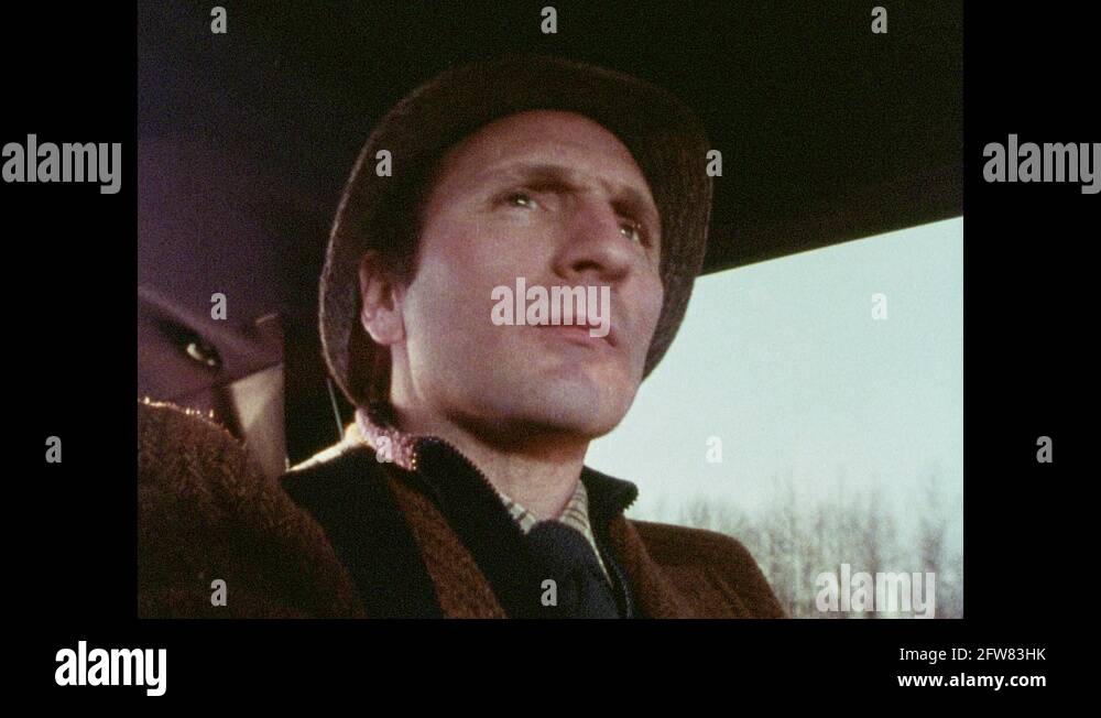 1980s: UNITED STATES: man sees exit sign. Exit sign by road. Cars ...