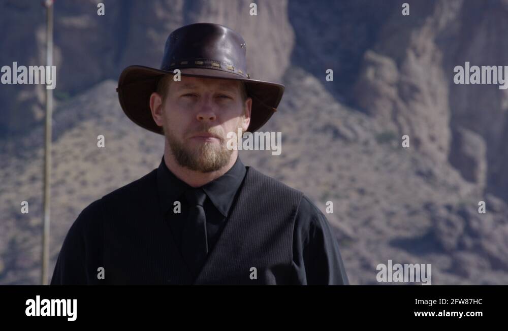 Cowboy spitting in front of mountain background Stock Video Footage - Alamy