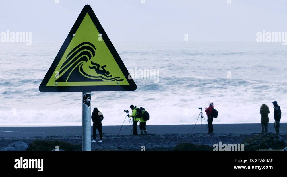 Iceland beach, wave danger warning sign, tourists, amateur ...