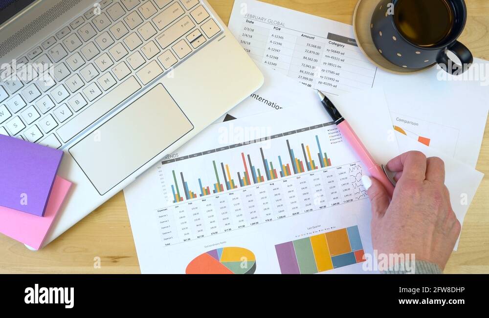 Setting up modern office desk overhead with laptop pc and graphs ...