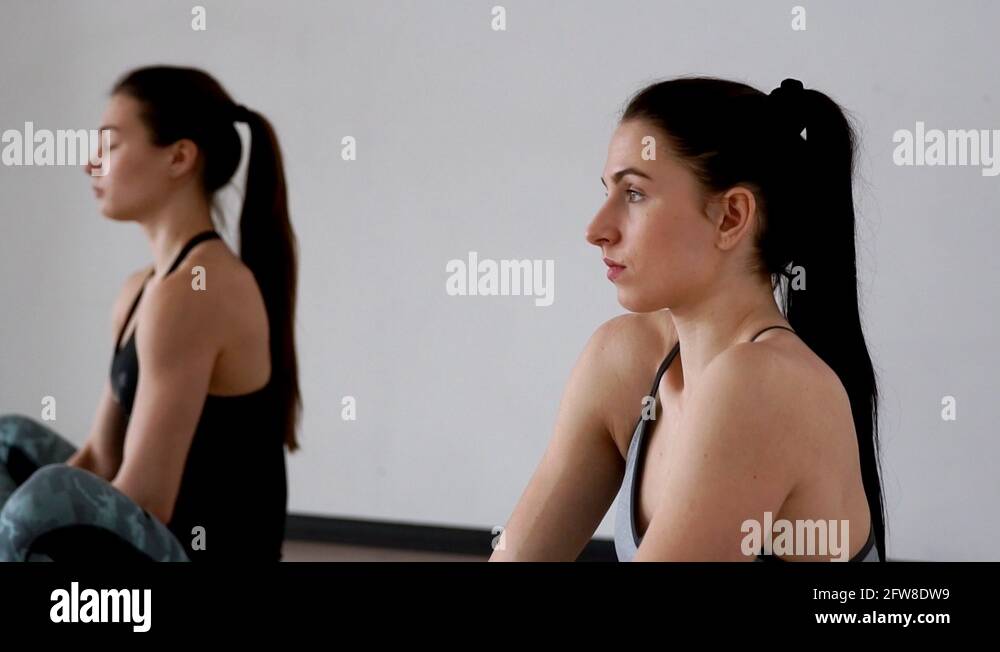 Beautiful girls perform an exercise for posture sitting in a butterfly ...