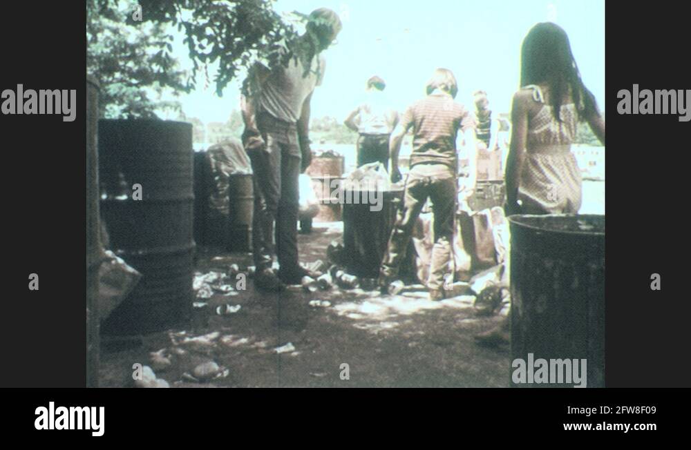 1970s: People work at recycling center. Man and boy stomp on cans Stock ...