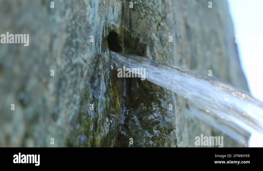 Water comes out of natural stone fountain. Wild stone water source ...