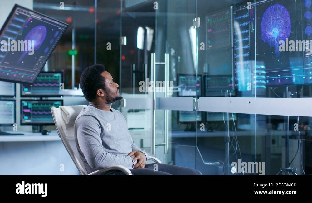 In Neurological Laboratory Man in a Chair Looks at Brain Scan ...