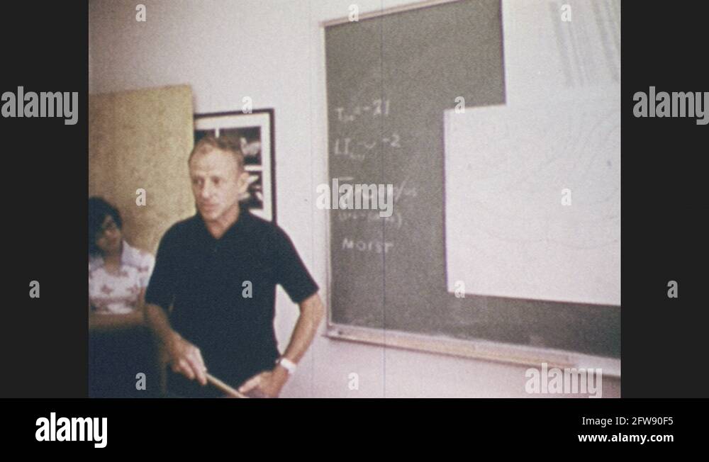 1970s: Man points to chalkboard. People watch. Woman types. Cards move ...