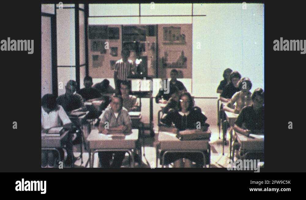 1960s: Kids in classroom, zoom in on projector in back of room. View ...