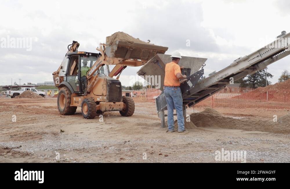 A Loader Drops Dirt Into A Dirt Conveyor Stock Video Footage - Alamy