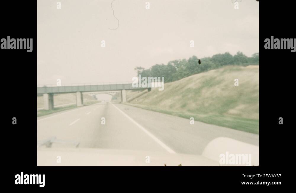 1950s: Tracking shots from car, driving on highway. Exiting highway ...