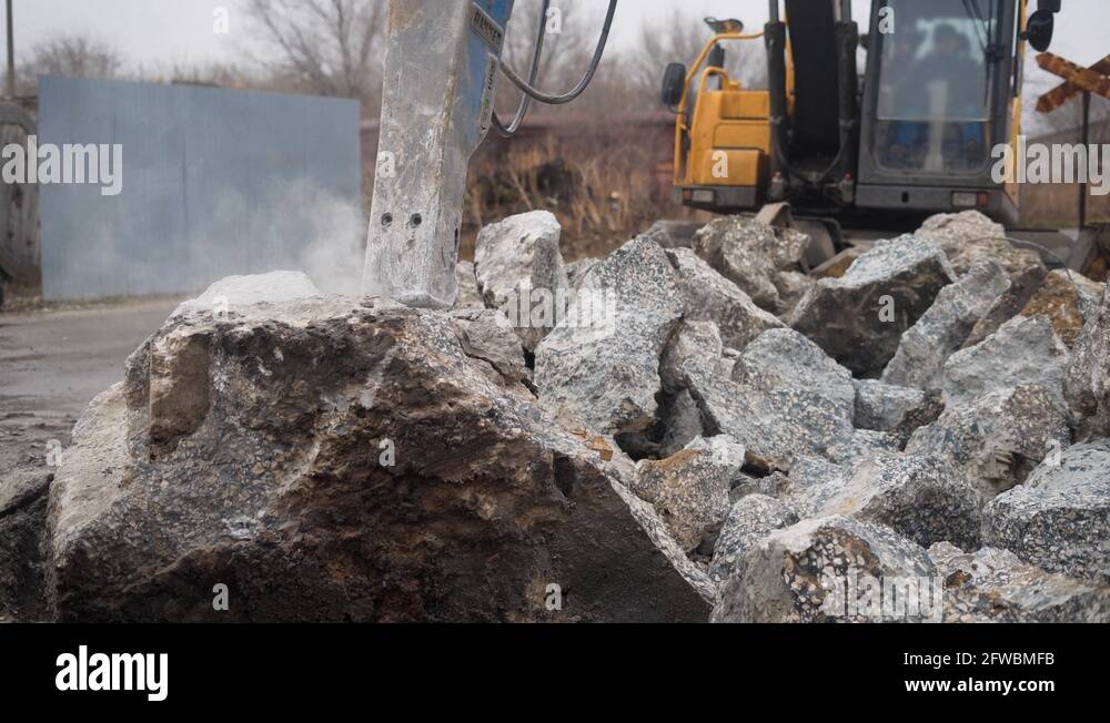 Big excavator breaking stones to gravel while working on construction ...