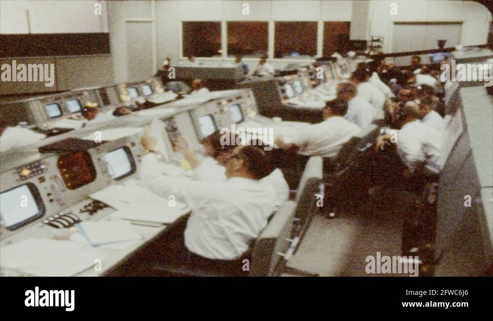 1960s: Men at control panels. Men at control panel, look at monitors ...