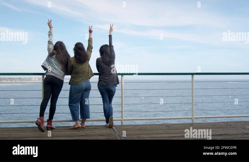 Friends Pose With Peace Signs, Woman In Center Turns And Smiles At ...