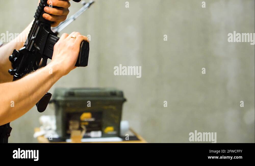 White male adult loads and cocks an assault rifle in slow motion at a ...