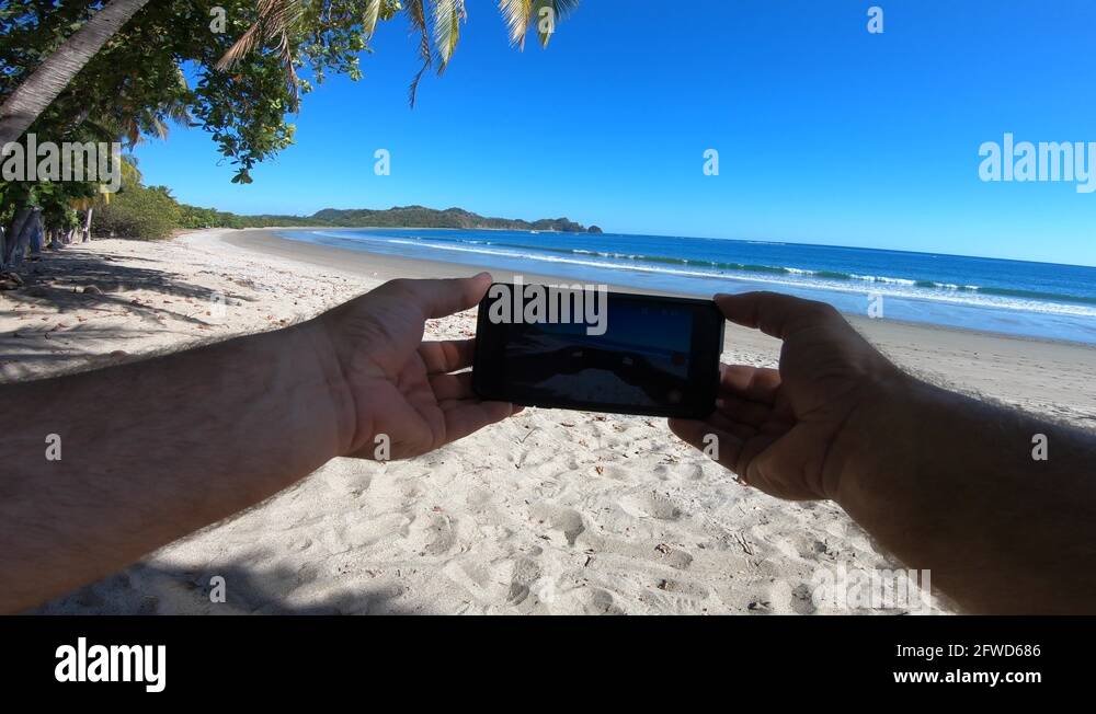 POV of a man taking photos of a scenic empty beach, slow motion Stock ...